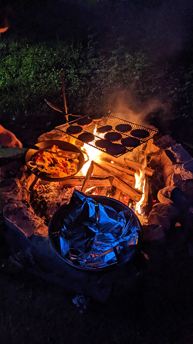 Campfire cooking at its finest&mdash;where burgers taste better and conversations grow deeper as the flames dance into the night.
