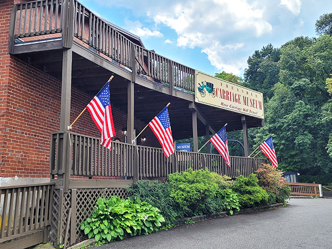 The Carriage Museum stands proudly decorated with American flags, celebrating transportation history before gas prices became dinner conversation.