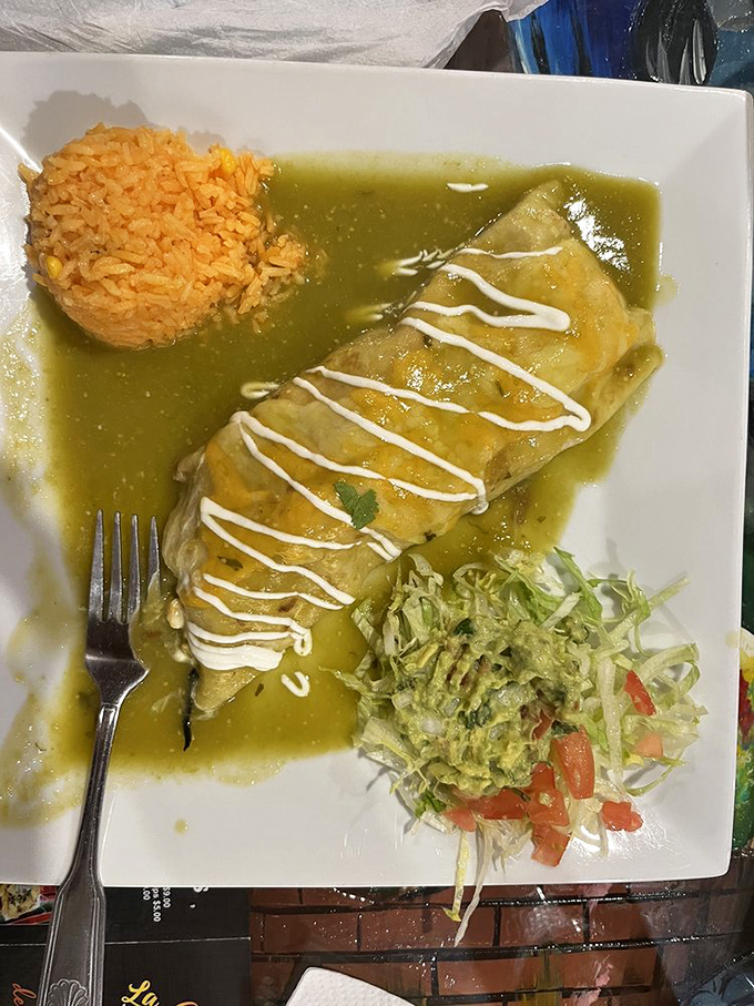 Green sauce enchiladas swimming in a verdant pool of flavor. That perfectly molded rice isn't just a side—it's architecture you can eat.