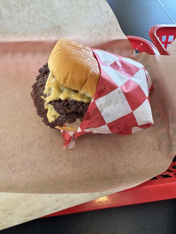 Wrapped in that iconic red-and-white checkered paper, this burger whispers sweet promises of satisfaction without a hint of pretension.