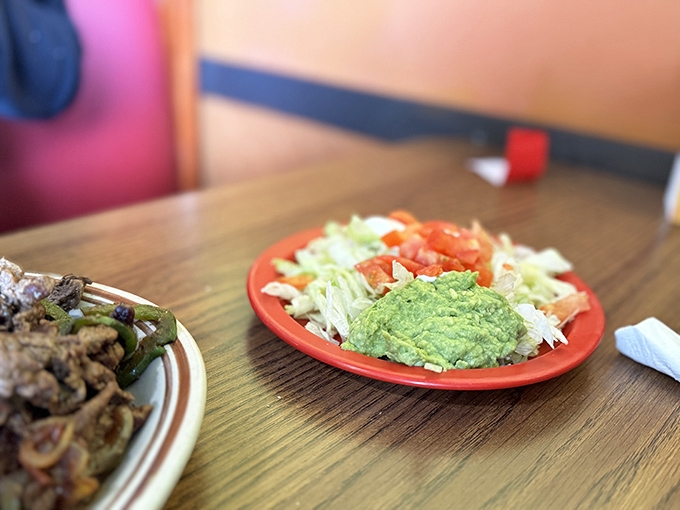 Fresh guacamole that's so vibrant it makes the plate look like it's growing an avocado garden right before your eyes.