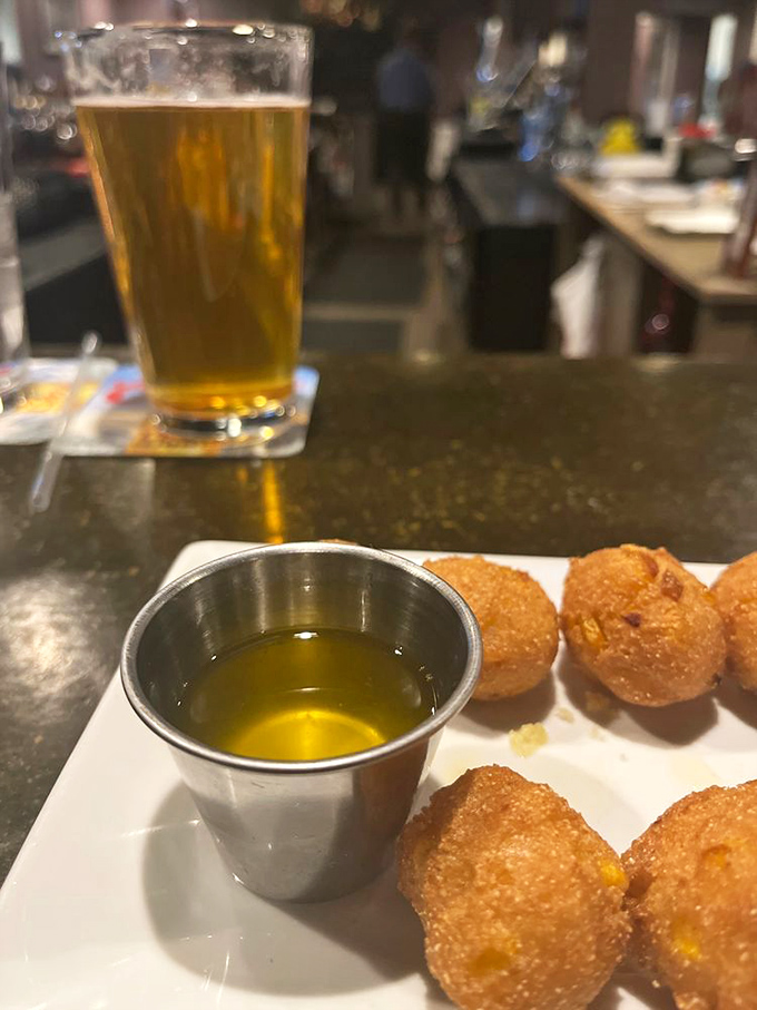 Golden hush puppies stand at attention beside a cold beer&mdash;the perfect prelude to the steak symphony that awaits.