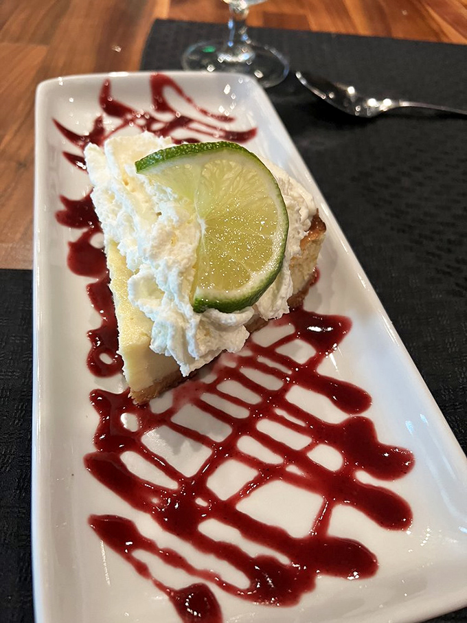 Key lime pie with a raspberry drizzle that zigzags across the plate like a sweet roadmap to dessert heaven.
