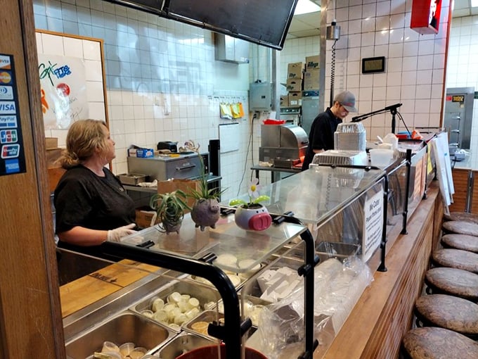 The frontlines of flavor, where BBQ artists craft masterpieces behind glass. It's like watching sculptors, but the medium is meat.