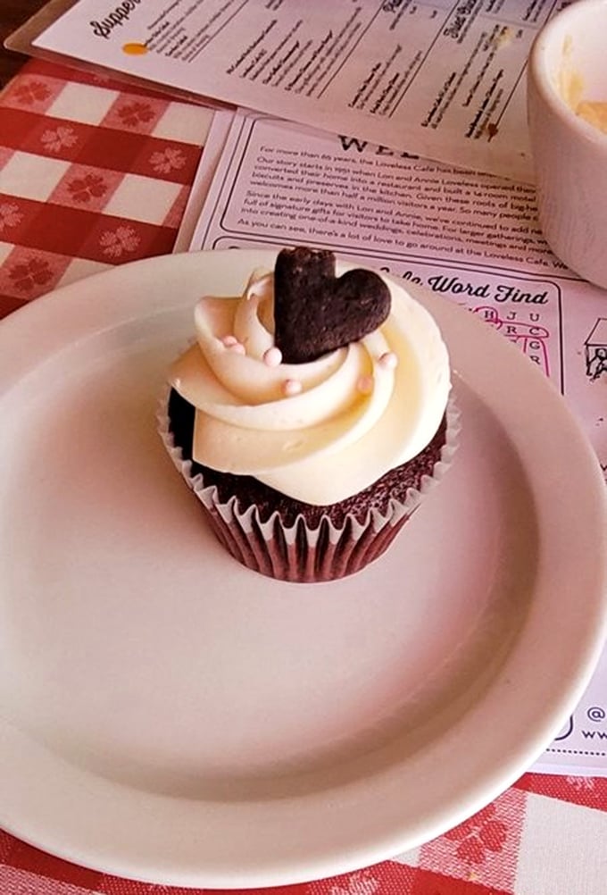 A chocolate cupcake crowned with creamy frosting and a chocolate heart, because true love is dessert after breakfast.