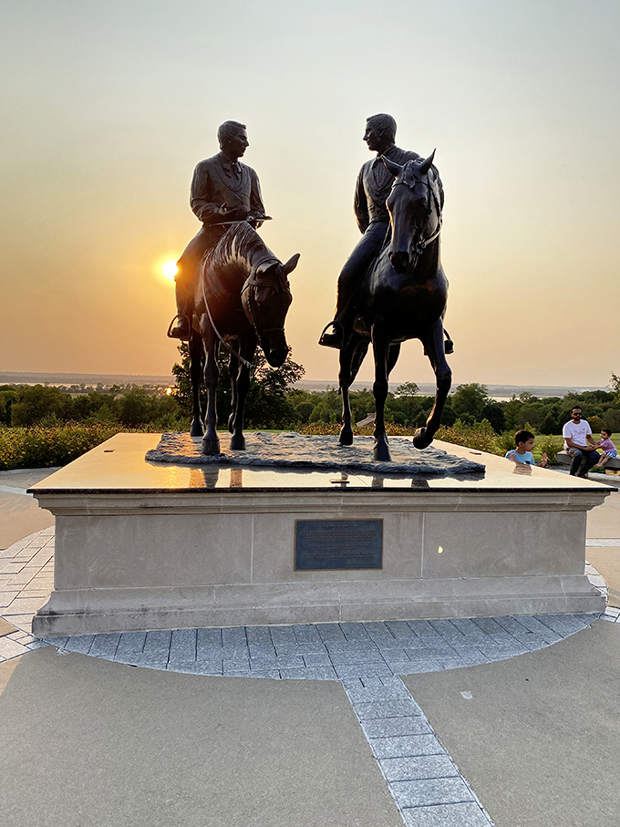 Silhouetted against the sunset, these bronze horsemen create a dramatic tableau that captures the spirit of the American frontier.