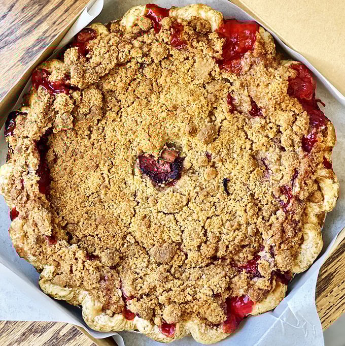 A crumbly crown guards the crimson treasure of strawberry-rhubarb filling. Summer and spring having a delicious argument in one pie.