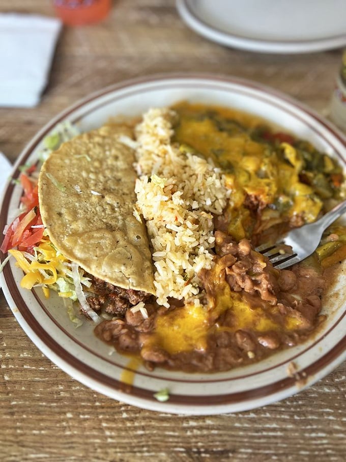 A fiesta on a plate: where rice, beans, cheese, and a perfectly crisped taco come together in harmonious Southwestern symphony.
