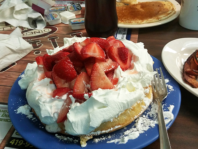 A mountain of whipped cream and fresh strawberries transforms this waffle from mere breakfast into what can only be described as morning dessert.