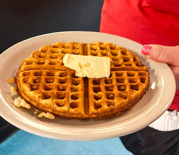 Golden, crispy waffles topped with a generous melting pat of butter await you for a comforting and delicious morning treat.