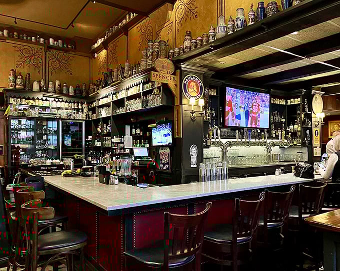 The bar gleams with promise, beer steins standing at attention above while staff below prepare to pour liquid happiness into your glass.