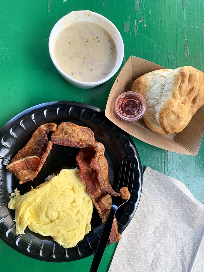 Breakfast fundamentals executed with respect: fluffy eggs, perfectly crisped bacon, and that biscuit standing by for gravy-soaking duty.