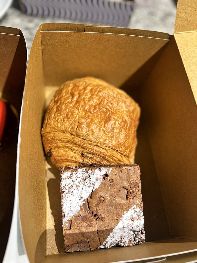 A chocolate brownie and pain au chocolat share a box like old friends, each one perfectly comfortable in its identity as an ambassador of butter and chocolate.