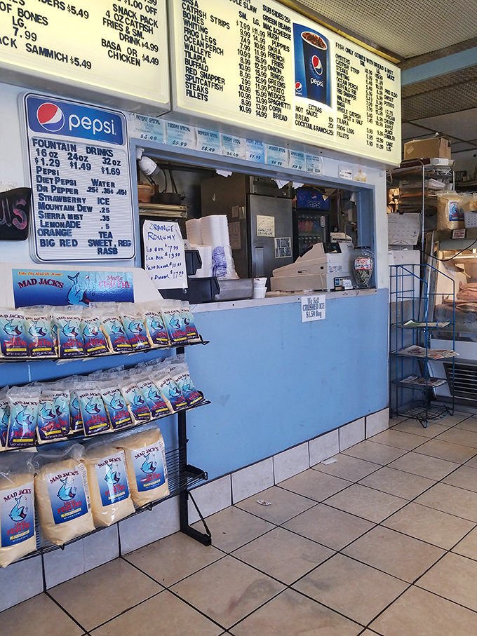 Behind this humble blue counter, culinary magic happens. The menu board above might be overwhelming for first-timers, but the staff is happy to guide you.