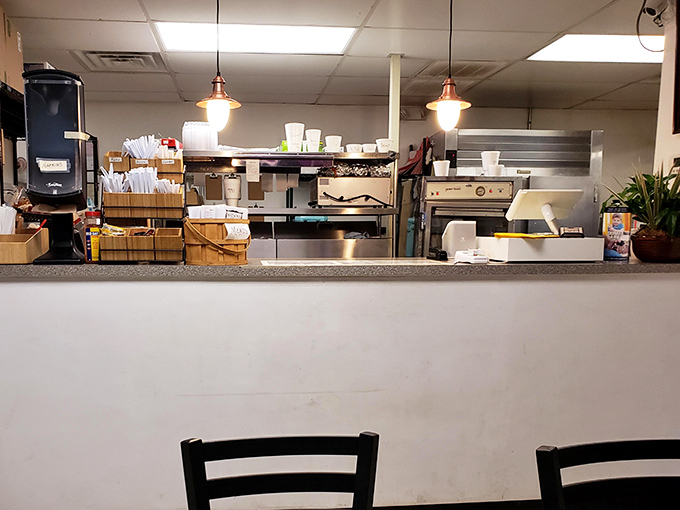 Behind this counter, culinary magic happens daily. The open kitchen design lets you witness the choreography of comfort food being prepared with care.
