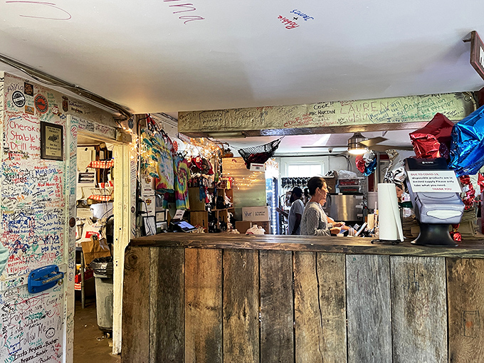 Behind this rustic wooden counter, barbecue magic happens. The patina isn't decoration; it's earned through years of smoke and service.