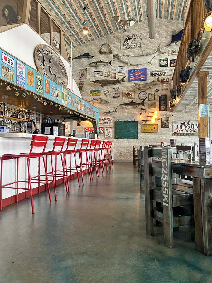 Red bar stools pop against whitewashed brick walls adorned with fishing trophies. The perfect stage for seafood drama to unfold.