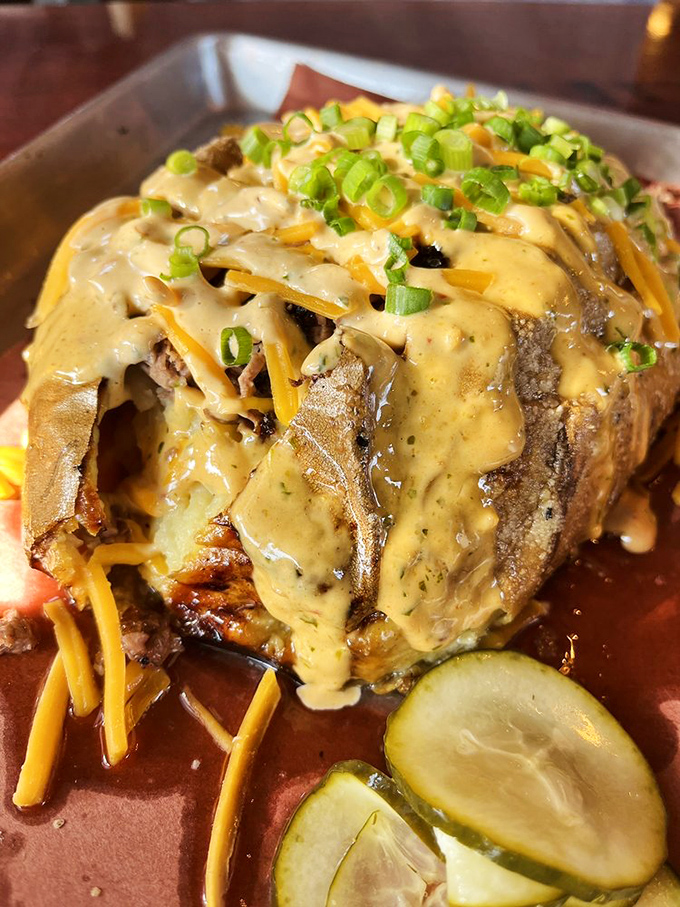 A loaded baked potato that's dressed better than most people at formal events, wearing its cheese sauce like a velvet robe.