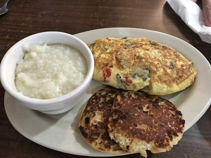 A fluffy veggie-packed omelet alongside golden biscuits and grits. The South's greatest breakfast hits, all on one harmonious plate.
