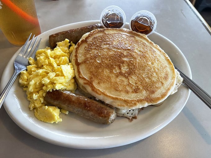 A pancake so perfectly golden it belongs in Fort Knox, with eggs and sausage standing guard. Breakfast doesn't get more American than this.