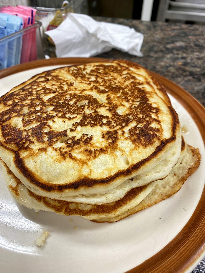 These pancakes aren't just stacked—they're architectural achievements with golden-brown exteriors hiding fluffy interiors that soak up syrup like sponges.