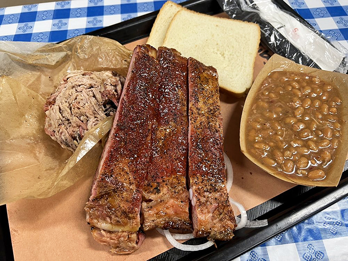 Ribs and pulled pork with sides that know their role—supporting the stars without trying to steal the show. That bread is just waiting to become an impromptu sandwich.