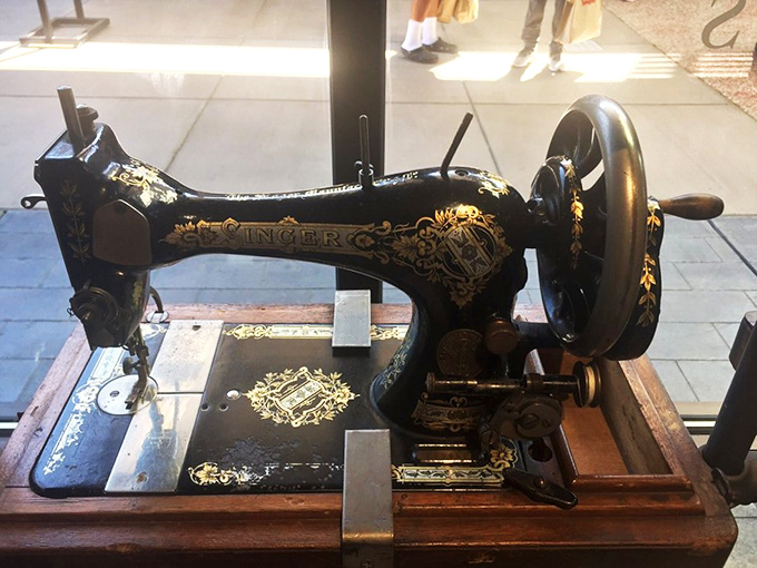 This vintage Singer sewing machine display reminds us that before fast fashion, clothes were investments—much like your outlet haul today.