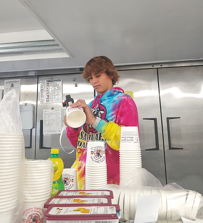Behind every great scoop is someone who understands the sacred responsibility of ice cream preparation. The tie-dye uniform suggests this is no ordinary server.