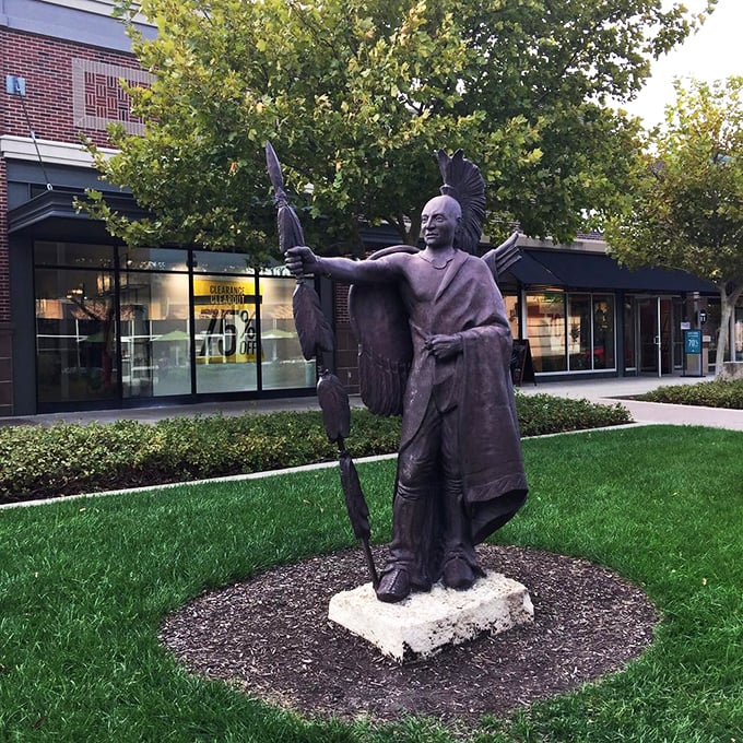 This Native American statue stands as a reminder of Kansas's rich heritage, watching over shoppers as they hunt for treasures of a different kind.
