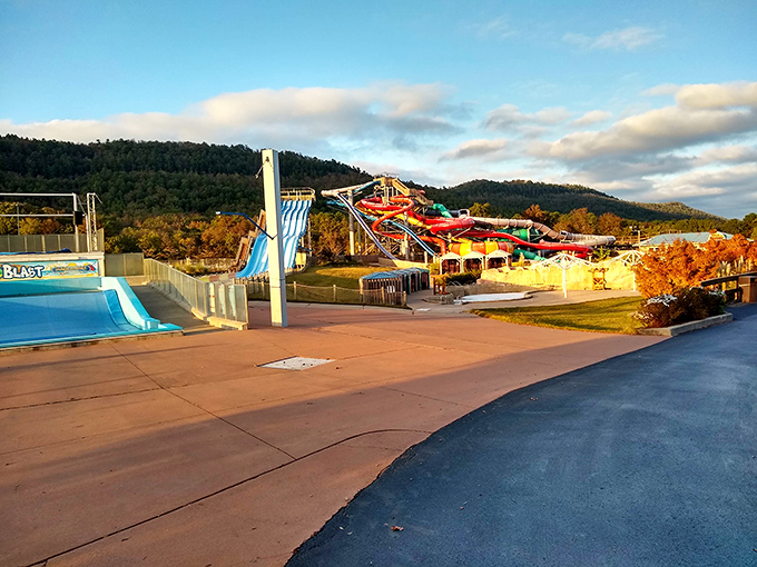 Golden hour bathes the water park in warm light, transforming ordinary concrete and water into a landscape of vacation memories waiting to happen.