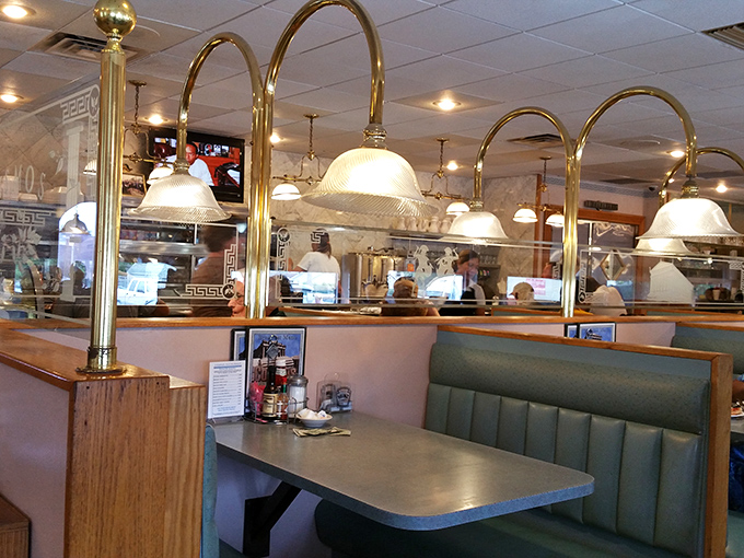 Brass arches frame the dining experience like a series of culinary portals, each booth offering its own little universe of comfort food possibilities.