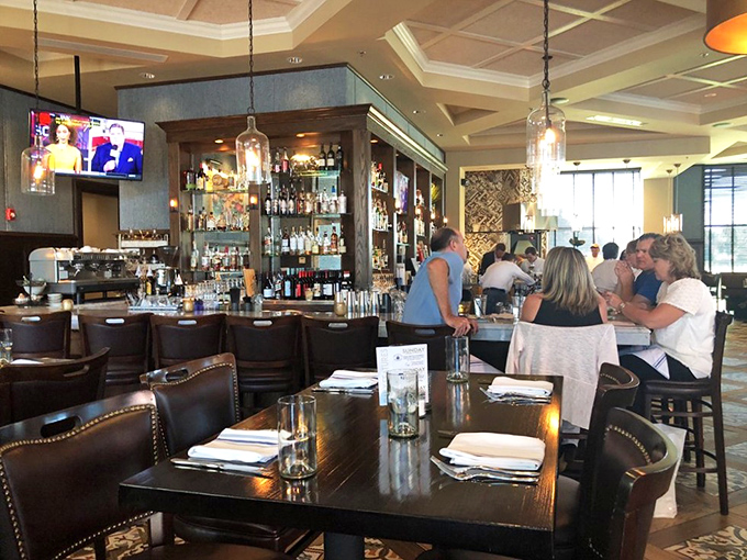 The bar area beckons with promises of bourbon-forward cocktails and conversations that flow as smoothly as the spirits.