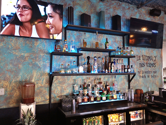 The bar at Cielo isn't just stocked&mdash;it's curated, with bottles arranged like a liquid library against that distinctive turquoise wall.