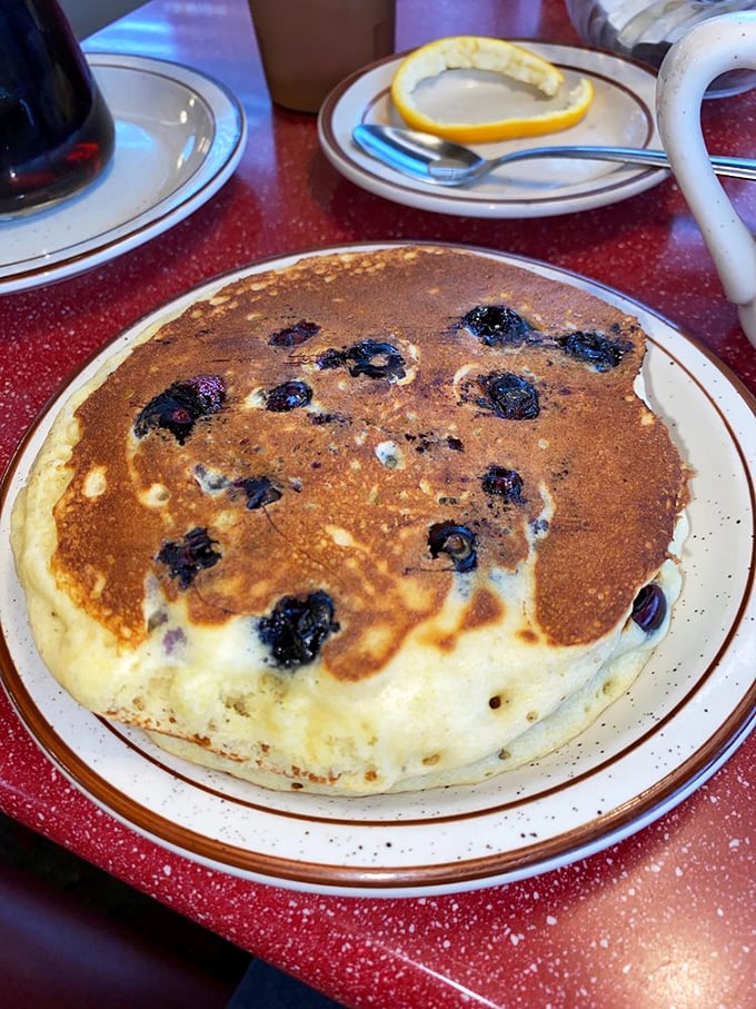 Blueberry pancakes that look like they were painted by Mother Nature herself. Each purple burst is a tiny flavor explosion waiting to happen.