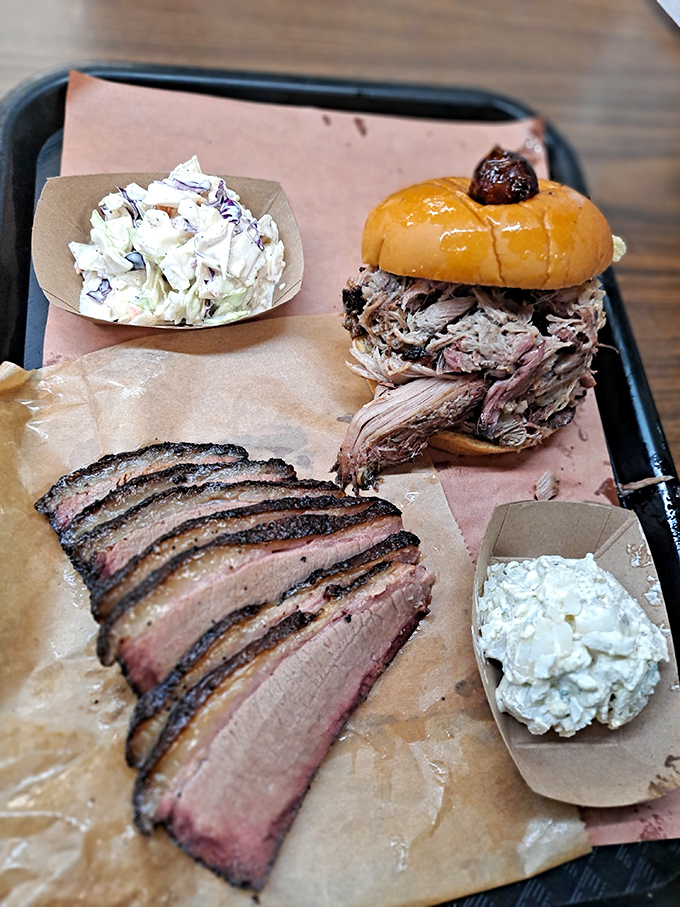 The BBQ trinity: sliced brisket, pulled pork sandwich, and sides that complement rather than compete. This tray should come with a warning: "May induce food coma."