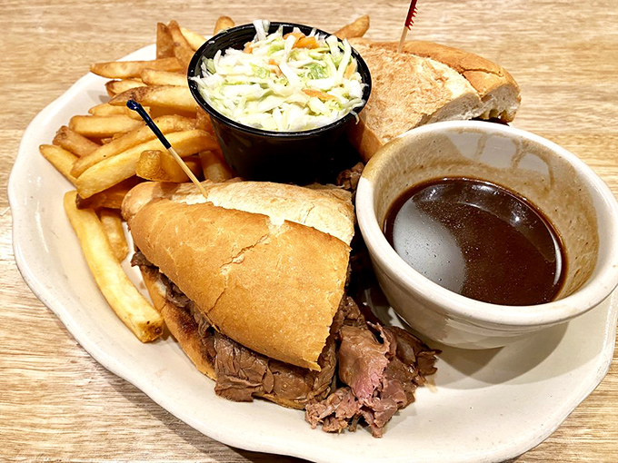 The brisket sandwich comes with its own supporting cast: creamy coleslaw, golden fries, and a pool of au jus waiting for its cameo appearance.