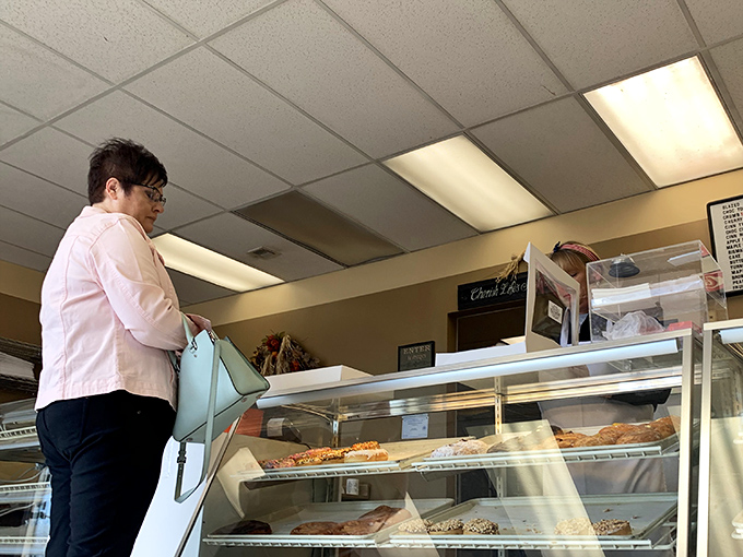 The moment of decision – a customer contemplates which circular masterpiece will complete their morning. Life's important choices happen at this counter.