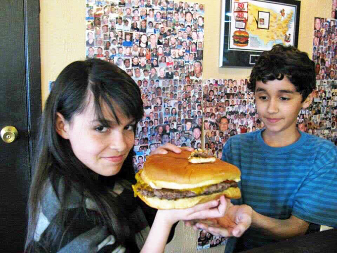 The look of determination meets the reality of a challenge burger. Some mountains are made of meat, and they must be conquered.