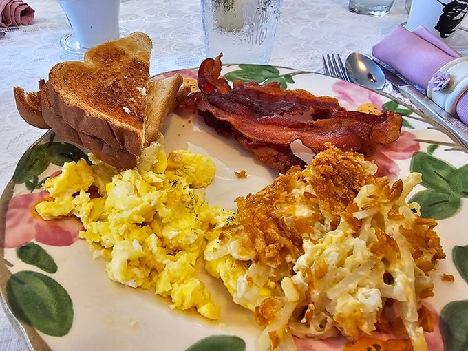 The breakfast trinity: perfectly scrambled eggs, crispy bacon, and what appears to be hash brown casserole&mdash;proof that classics never go out of style.
