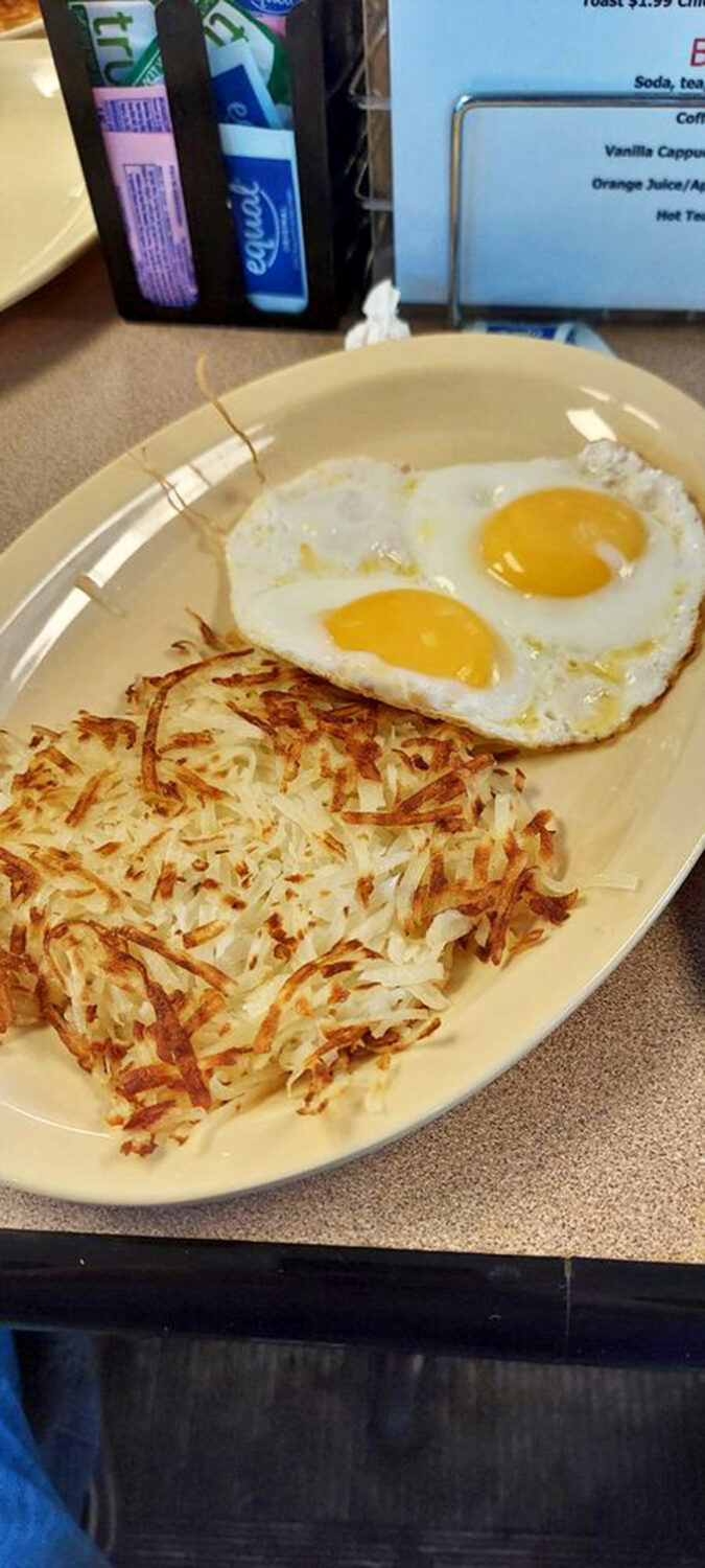 Sunny-side up eggs keeping watch over a kingdom of perfectly crisped hash browns. Morning perfection doesn't need to be complicated&mdash;just perfectly executed.
