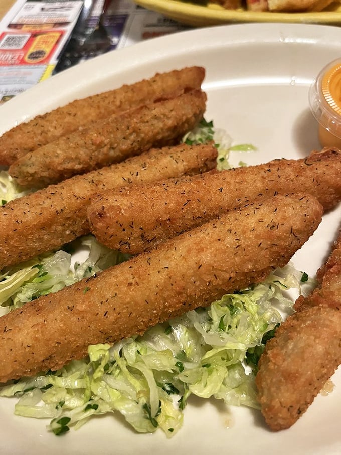Fried pickles lounging on a bed of lettuce like sunbathers at the beach, waiting to take a dip in that tangy dipping sauce.