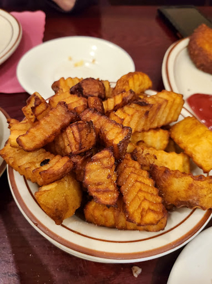 Crinkle-cut fries that have achieved the perfect golden state &ndash; crispy exterior, fluffy interior, and zero regrets.
