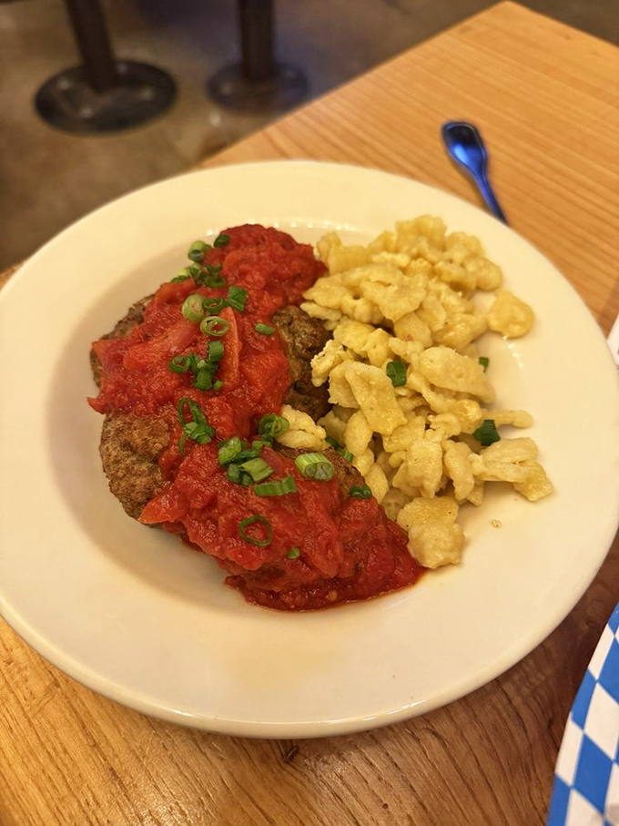 Savory meat topped with vibrant tomato sauce and a side of tender spaetzle offers a hearty, delicious meal for you.
