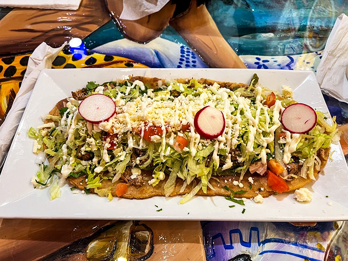 Red enchiladas draped in sauce and cream like they're dressed for their own delicious quinceañera. The rice and beans are just bonus points.
