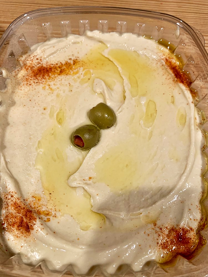 Hummus so smooth it could talk its way out of a traffic ticket. Those two olives are like Mediterranean eyes staring into your hungry soul.
