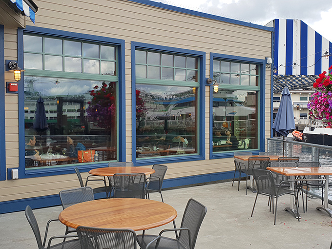 Blue-trimmed windows frame Seattle's working waterfront, where outdoor tables await your seafood feast with a side of fresh air.