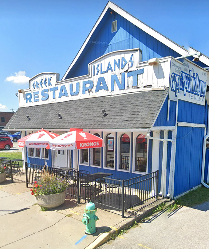 Sunny days call for outdoor seating at this blue and white neighborhood beacon. The Kronos umbrella knows exactly what it's advertising.
