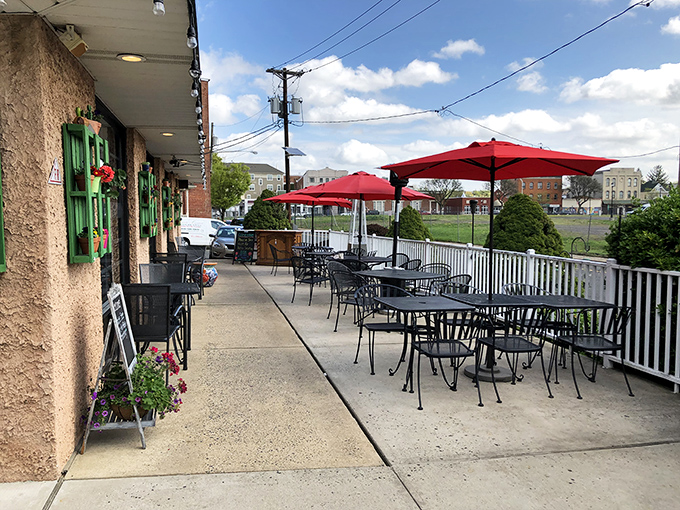Sidewalk dining that feels like a secret discovery&mdash;red umbrellas offering shade while you savor both your meal and people-watching.