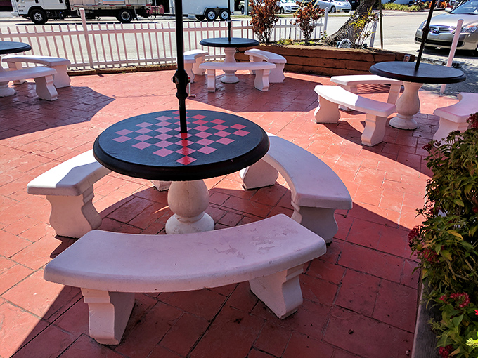 The outdoor seating area offers checkerboard tables where ice cream enthusiasts can engage in deep philosophical debates about sprinkles versus jimmies.
