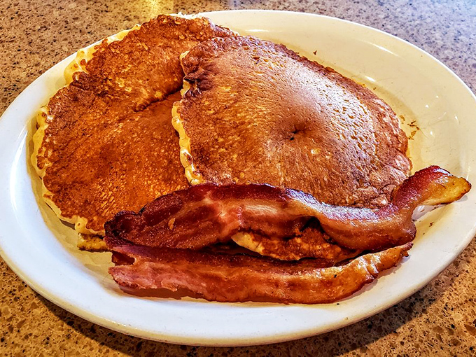 Pancakes so golden they deserve their own currency, with bacon that's achieved that perfect crispy-yet-chewy consistency that science still can't explain. 